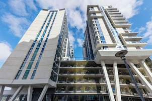 Um edifício moderno alto, com várias varandas e janelas amplas.