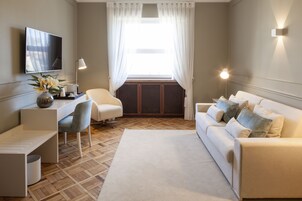 Uma sala de estar moderna com um sofá, uma escrivaninha e uma televisão.