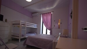 Quarto com beliches, escrivaninha e cadeira.