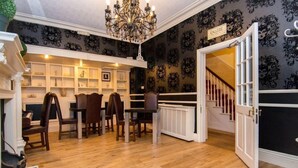 Uma área de refeições com um candelabro, cadeiras de madeira e um radiador branco.