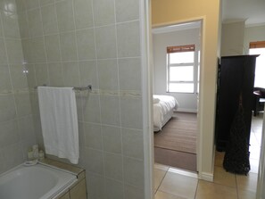 Um banheiro com banheira, porta-toalhas e chuveiro.
