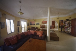 Uma sala de estar espaçosa com um sofá grande, uma mesa de centro de madeira e uma estante.