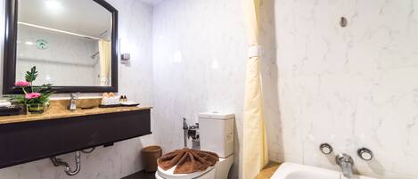 Casa de banho com sanita, lavatório e banheira.