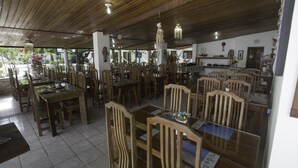 Um restaurante amplo com mobiliário de madeira e chão de azulejos.