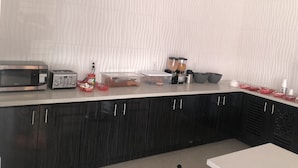 Uma cozinha moderna com micro-ondas, torradeira e vários recipientes sobre o balcão.