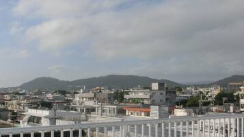 Paisagem urbana com edifícios e montanhas ao fundo.
