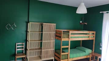 Quarto com uma cama de beliche, uma cadeira de madeira, uma estante e uma luminária pendente.