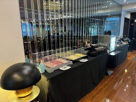 Disposição de buffet com diversos alimentos e um refrigerador de Coca-Cola.