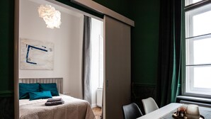 Quarto moderno com uma cama, uma mesa com bandeja e vista para o exterior.