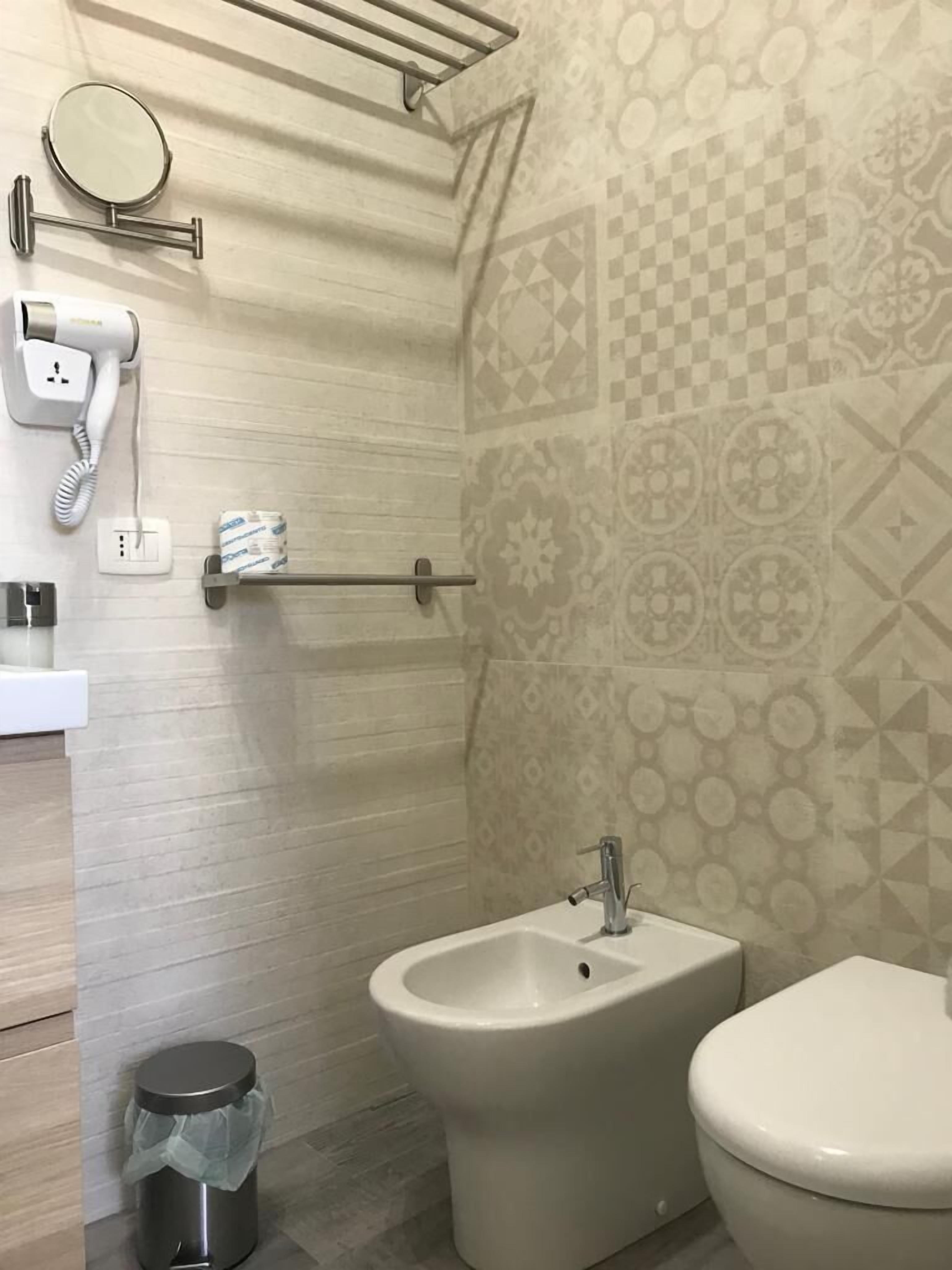 Casa de banho com bidé, sanita e porta-toalhas.