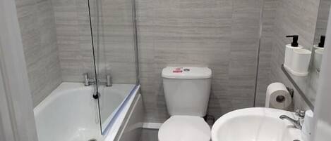 Um banheiro moderno com banheira, vaso sanitário e pia.