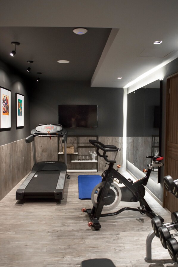 Uma academia moderna com esteira, bicicleta ergométrica e equipamentos de exercícios.