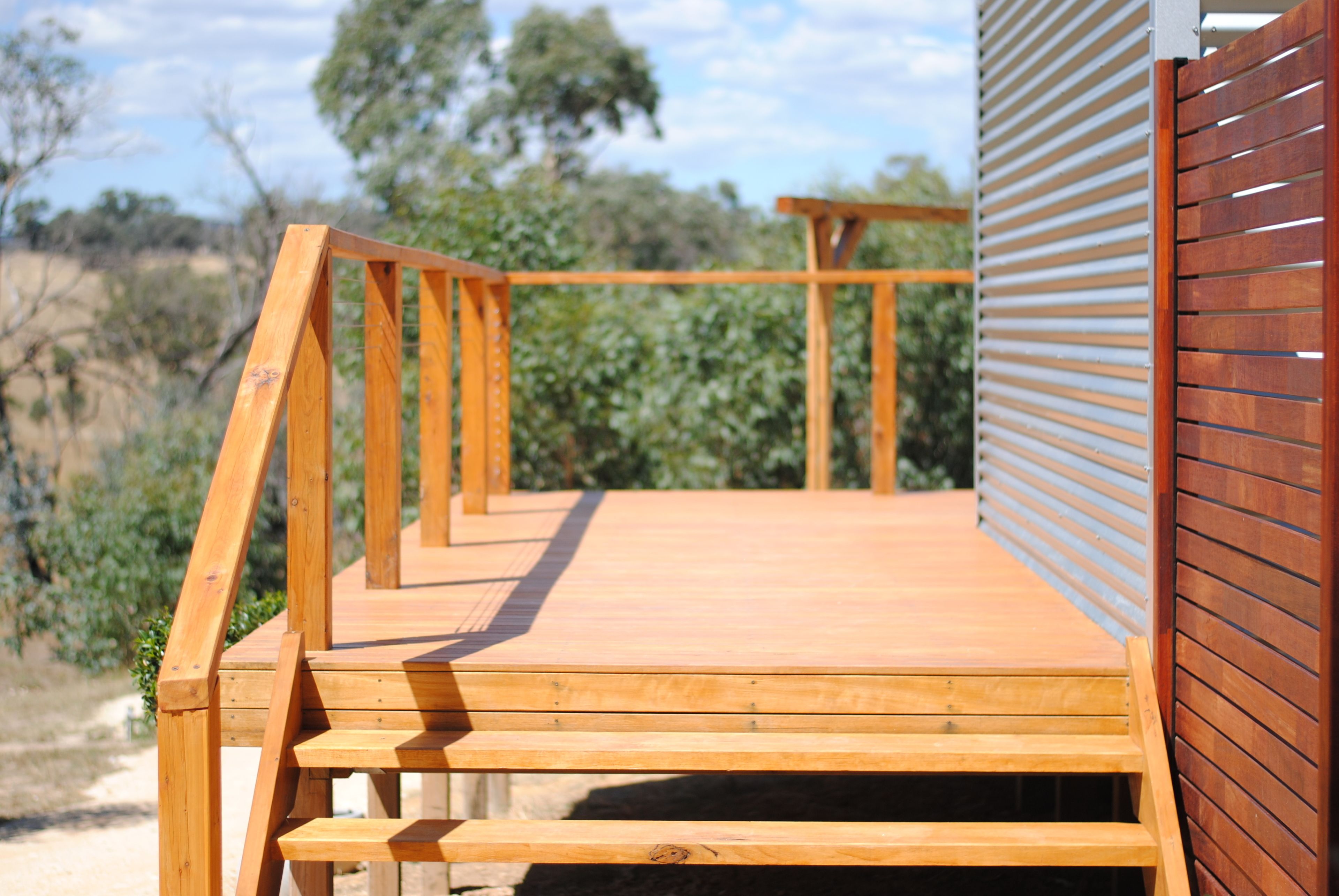 Um deck de madeira com escadas que levam a um edifício.
