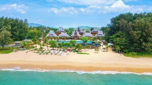 Resort com vários edifícios, praia e área de piscina.