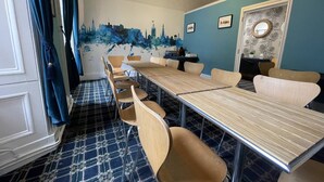Uma sala de conferências com uma mesa comprida e cadeiras, um mural com vista para a cidade na parede e um piso estampado.