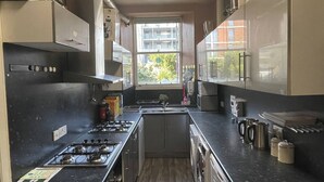 Cozinha moderna com fogão a gás, pia e eletrodomésticos de aço inoxidável.