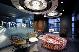 Um interior moderno com área de estar circular, paredes de vidro e luminárias de teto originais.