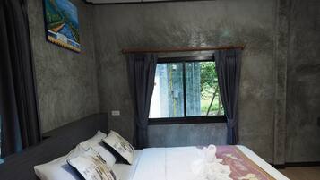 Quarto com cama, janela e um quadro na parede.