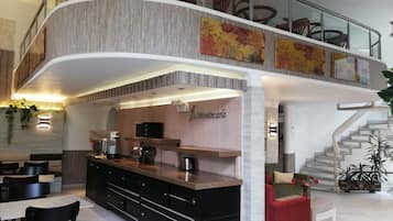 Cozinha moderna com área de bar, escada e assentos.