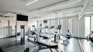 Uma academia moderna com esteiras, aparelhos de musculação e halteres.