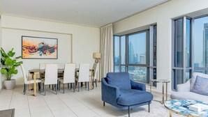 Uma sala de estar moderna com área de jantar, janelas amplas e vista para a cidade.