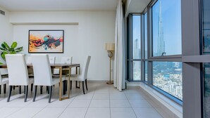 Uma sala de jantar moderna com vista para a cidade, uma janela grande e um quadro na parede.
