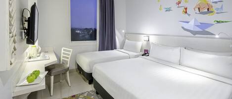 Quarto de hotel com duas camas, uma mesa de trabalho com cadeira, televisão e janela com cortinas.