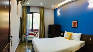 Quarto de hotel com cama, escrivaninha, cadeira e janela com cortinas.