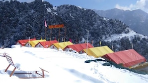 Uma montanha coberta de neve com tendas identificadas como "The Sky Village".