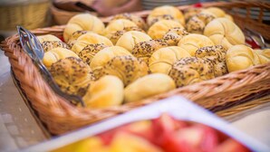 Uma cesta com pães redondos cobertos de sementes de gergelim.