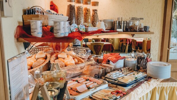 Buffet com diversos alimentos, utensílios e recipientes.