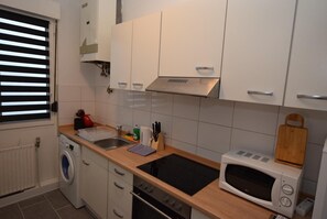 Um frigorífico, uma placa de cozinha, utensílios de cozinha 