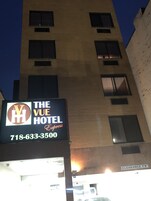 Placa de hotel com o nome 'The Vue Hotel Express' e um número de telefone.