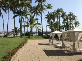 Uma praia privada, espreguiçadeiras, guarda-sóis de praia 