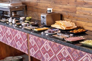 Um balcão de buffet com diversos alimentos e uma máquina de café.