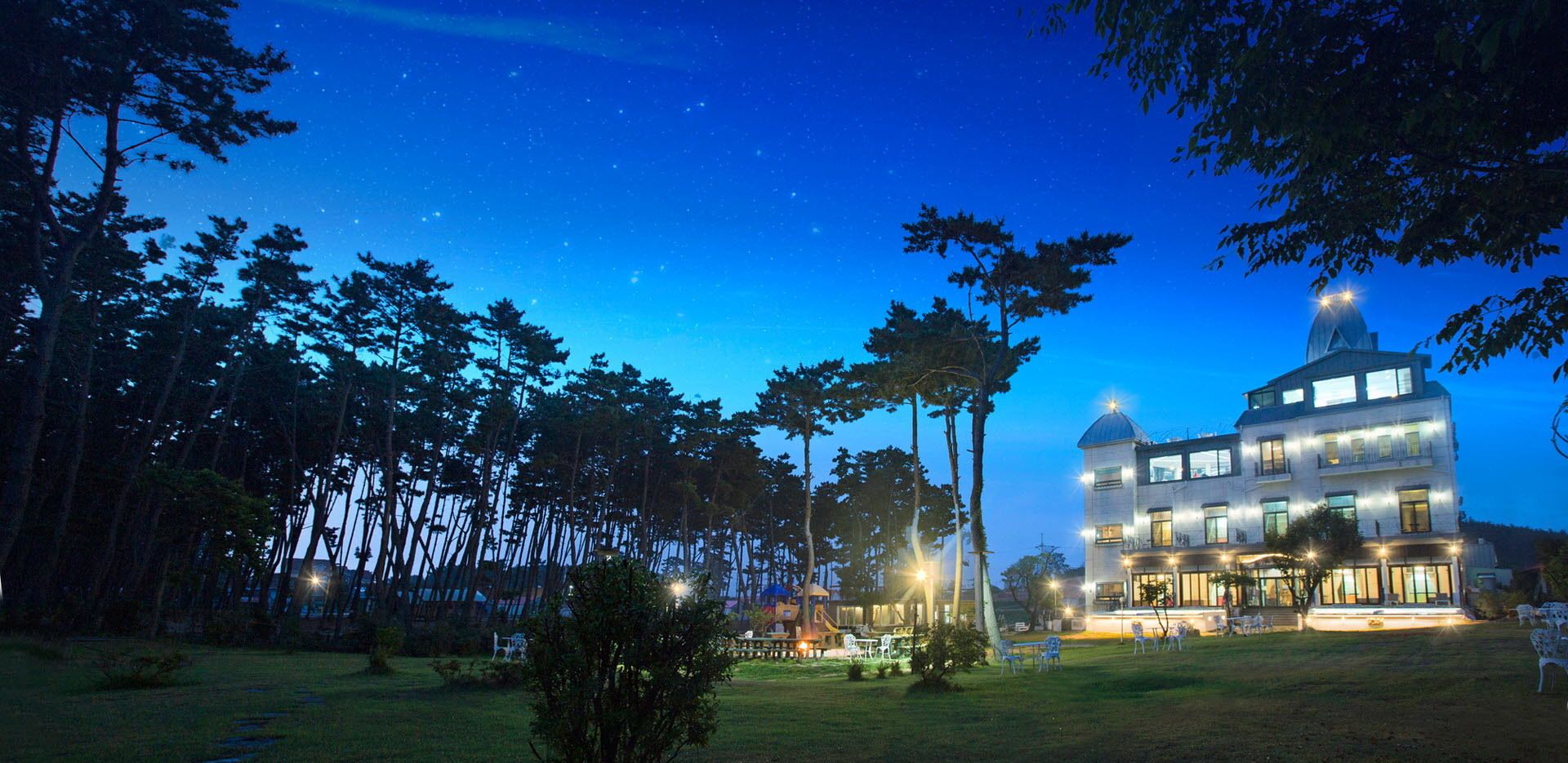 Um hotel de vários andares com design moderno, rodeado por uma área arborizada.