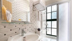 Casa de banho moderna com uma grande lavatório branco, uma prateleira de vidro, um porta-toalhas e uma janela com vista.