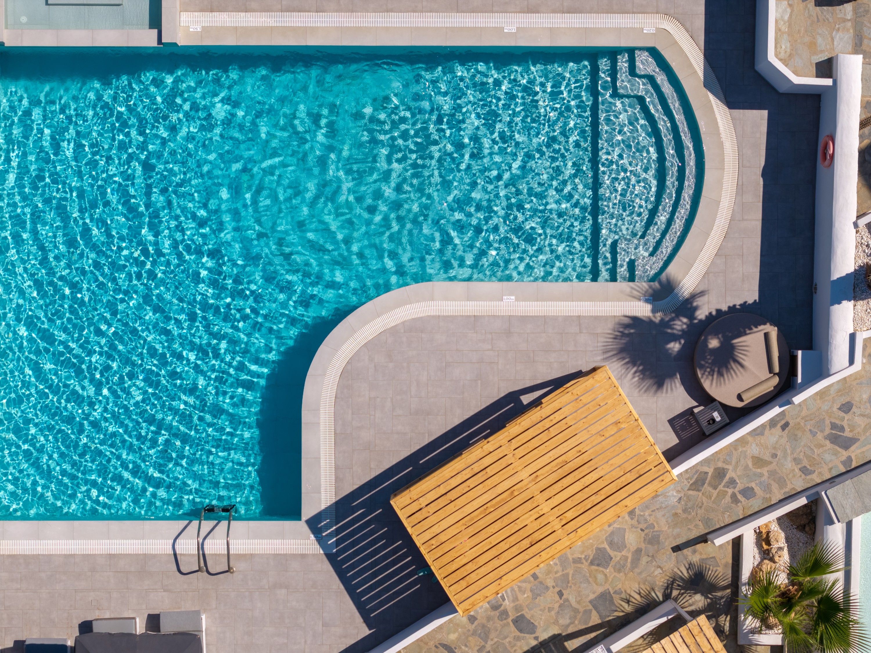 Vista aérea de uma piscina com espreguiçadeira e posto de salva-vidas.
