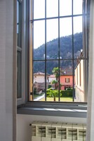 Uma janela com vista para uma colina e edifícios.