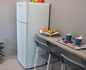 Refrigerador em uma área comum, chaleira elétrica