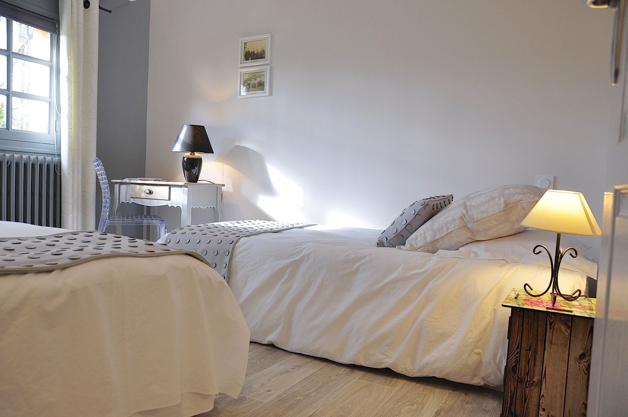Quarto com duas camas, uma escrivaninha e mesa de cabeceira com abajures.