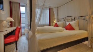 Quarto de hotel com cama, escrivaninha e cadeira.