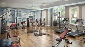 Uma academia ampla com equipamentos de cardio, aparelhos de musculação e pesos livres.
