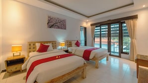 Quarto de hotel com duas camas, uma varanda e um quadro na parede.