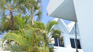 Um edifício moderno com fachada branca e estrutura de telhado triangular.