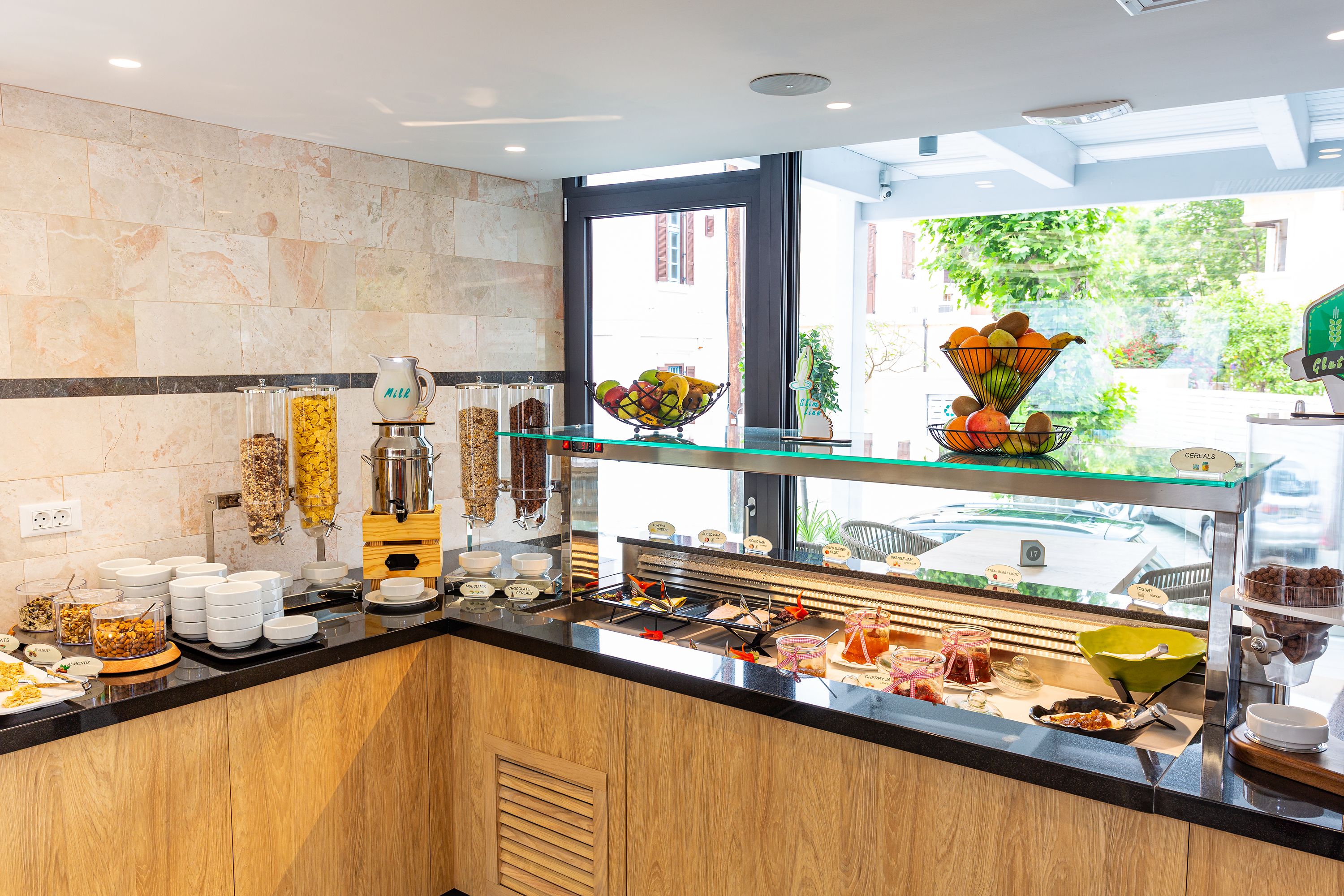 Buffet de café da manhã com diversas opções de comida e um espaço para café.