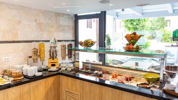 Buffet de café da manhã com diversas opções de comida e um espaço para café.