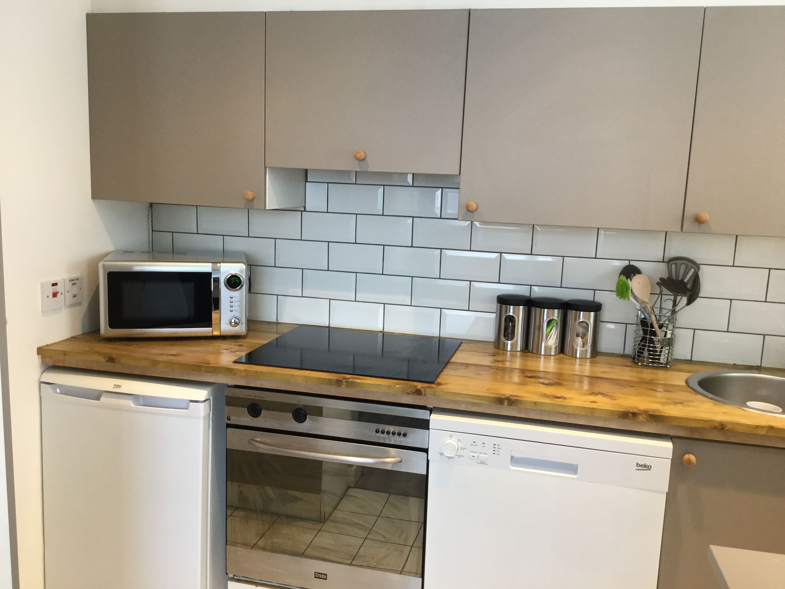 Um forno, uma placa de cozinha, uma máquina de lavar louça 