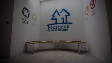 Uma sala de conferências com uma mesa comprida e cadeiras, um quadro branco com logotipos e uma parede lisa.