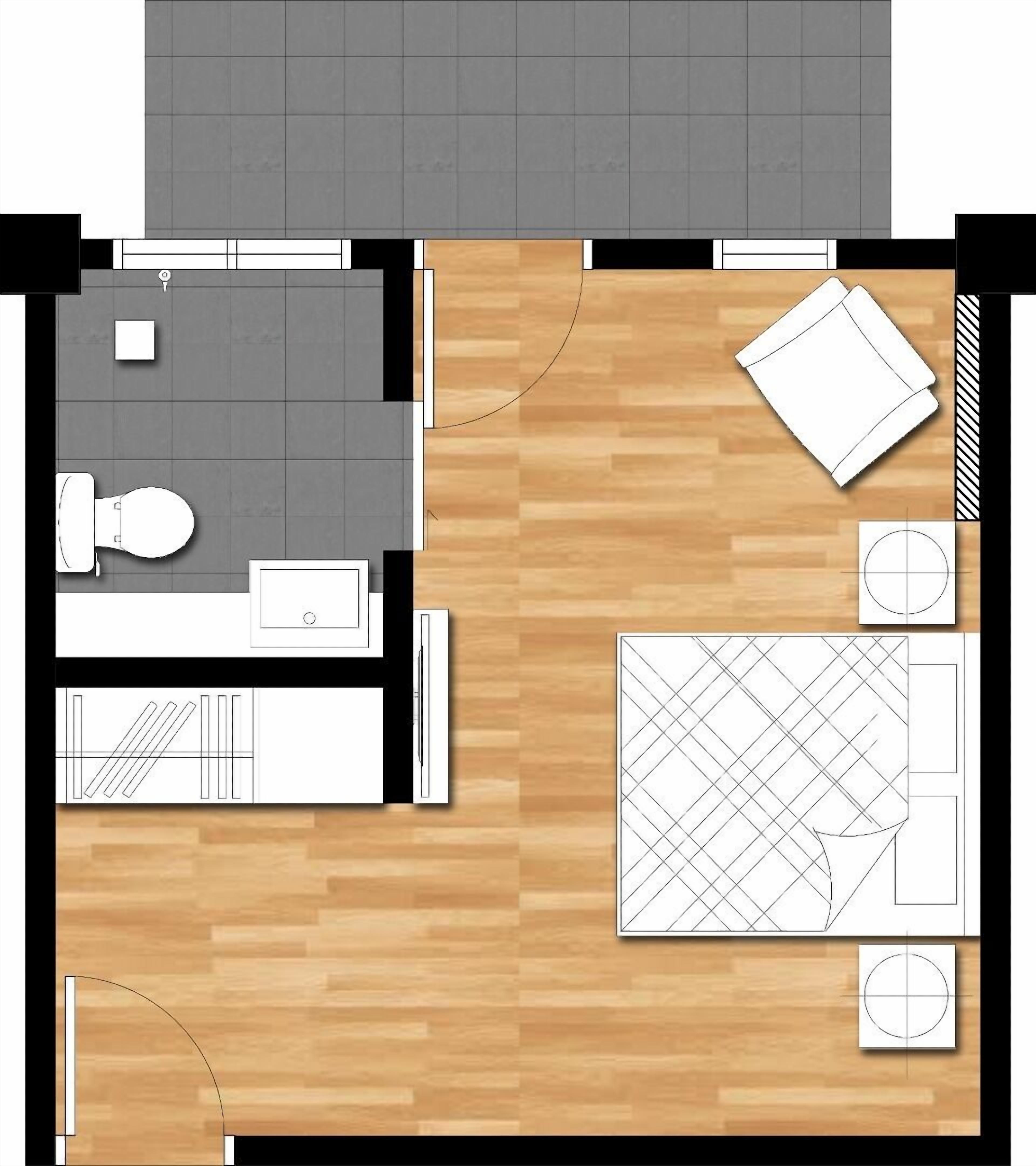 Planta baixa de um quarto de hotel com banheiro, cozinha compacta, uma cama e um pequeno espaço para sentar.